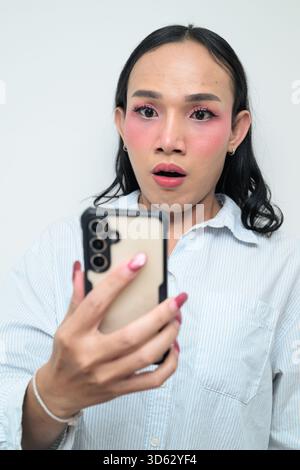 Surprised reaction of a young woman while using her smartphone indoors ...