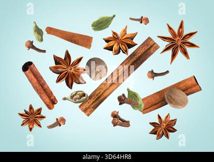 Christmas spices falling on light blue background Stock Photo - Alamy