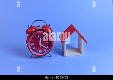 House Model and alarm clock on pink background Stock Photo - Alamy
