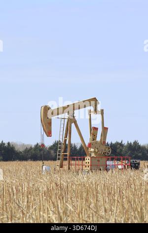 Oil Well Pump in a farm field with stubble and blue sky Stock Photo - Alamy