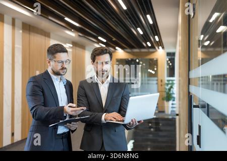 Two businessmen discussing the project details and looking involved ...