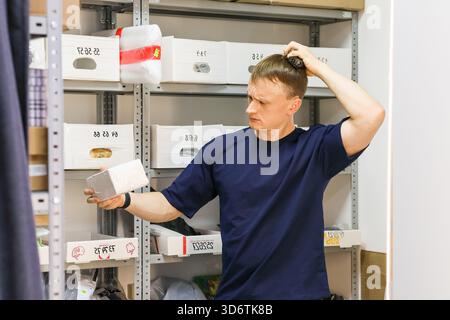 Warehouse worker standing near bags with coffee beans in the coffee ...