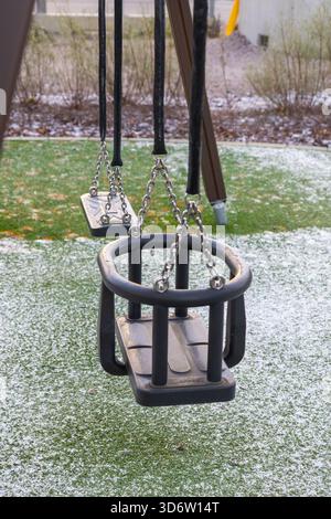 Snowy swings on the playground in a public park Stock Photo - Alamy