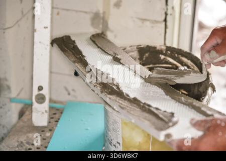 Construction worker applying paste on wall Stock Photo - Alamy