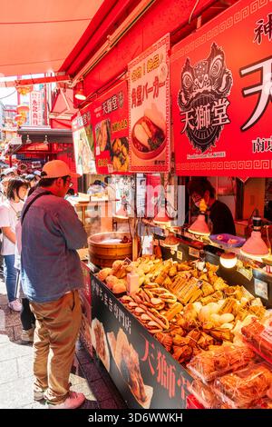 People queuing at a typical food counter stacked with steamed buns ...