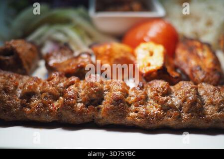 Grilled kebabs with vegetables and rice served on a plate Stock Photo ...