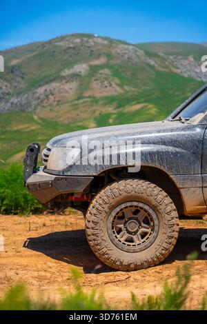 Front view of a green modified Land Rover Defender 90 on a dirt path ...