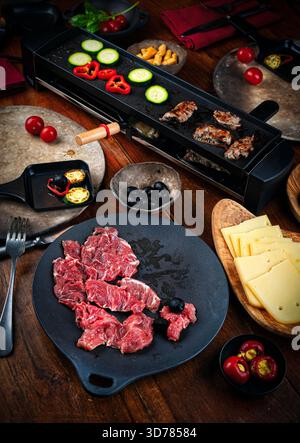 traditional authentic swiss raclette with beef meat, pickles, Savoy ...