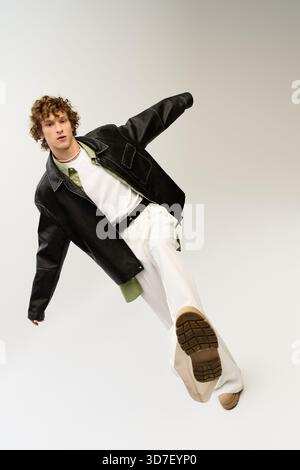 A young man strikes a pose showing off his muscles, framed by a pull up ...