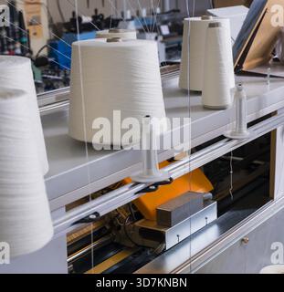 Spools with white thread at knitting shop view Stock Photo - Alamy