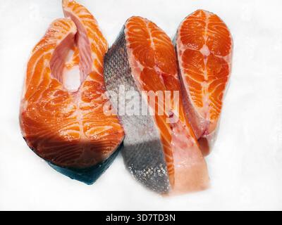 Raw salmon fillet with vibrant orange flesh dark skin on rustic wooden ...