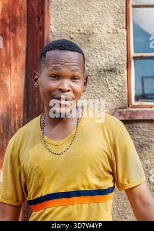 Surprised man in casual red tshirt giving thumb holding disposable cup ...