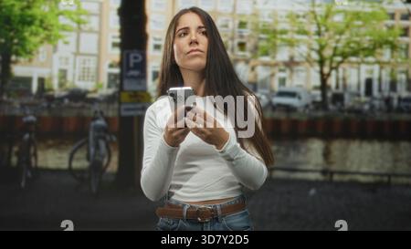 Female tapping on a cellphone at the railing Stock Photo - Alamy