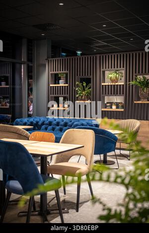 Cozy cafe interior featuring beige cushioned seating and modern ...