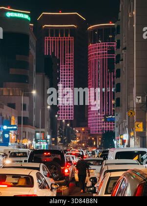 Illuminated Skyscrapers with Cars on Busy Night Street Stock Photo - Alamy