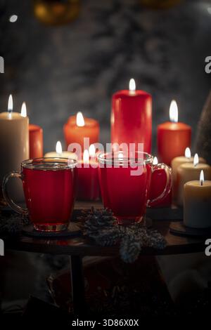 Red cup with hot tea and candles , near cozy fireplace, in country ...
