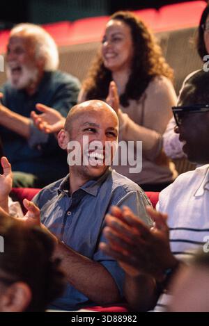 Bald man clapping with a beard in an outdoor urban street setting ...