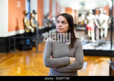 Female museum visitor examining with interest ancient armor Stock Photo ...