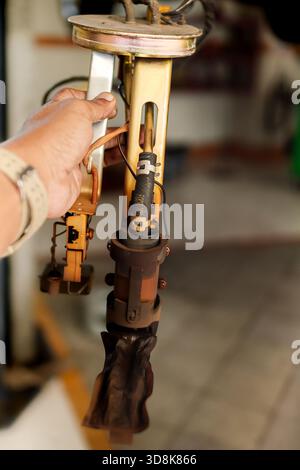 Hand of a car mechanic showing clogged fuel filter assembly at ...