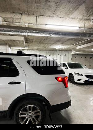 Parking lot with overhead dim light, underground parking garage Stock ...
