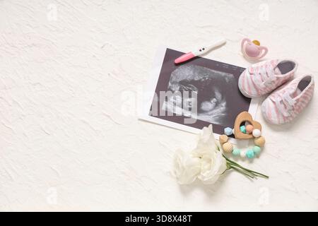 Composition with baby shoes, sonogram image, pregnancy test and toys on ...