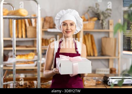 Young female seller with box of pastries Stock Photo - Alamy