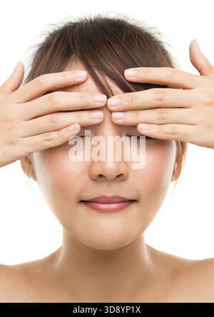 A closeup shot of a Japanese white-eye perched on a tree branch against ...
