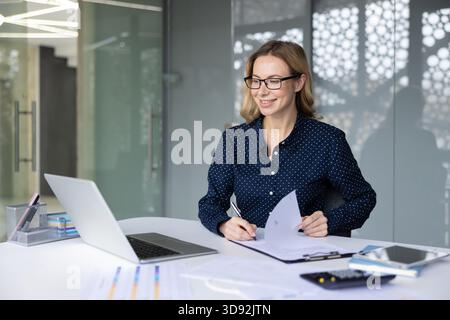 Professional businesswoman managing daily office tasks, reviewing ...