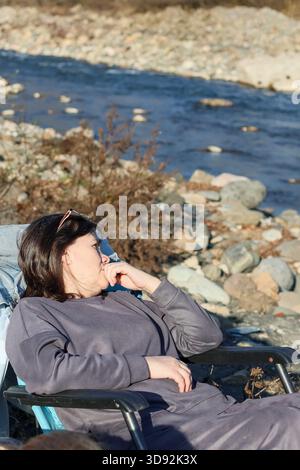 profile of brunette woman in sunglasses and leather coat in green light ...