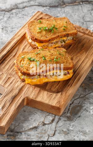Closeup of a fish with melted cheese on meat and slices of tomatoes and ...