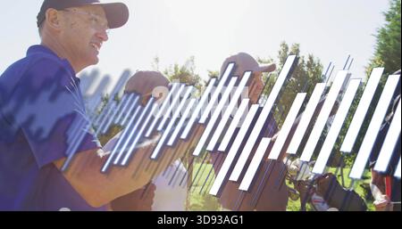 Standing four golfers holding clubs on fairway, in polos and hats, with ...