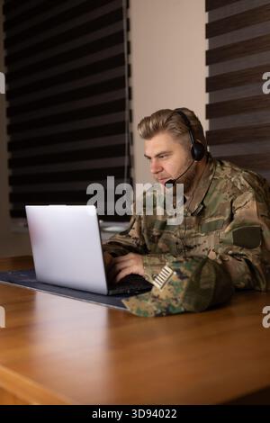 Military service. Young soldier working at wooden table in office Stock ...