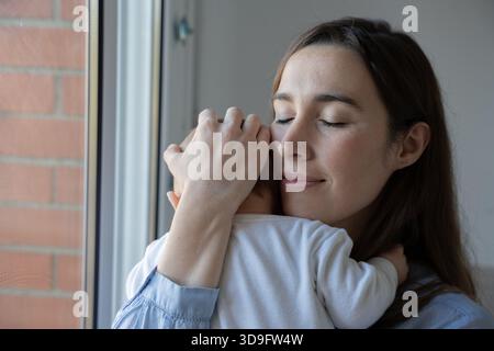 New mother tenderly hugging her newborn infant, showing affection and a ...