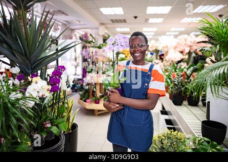 Young african american woman florist smiling confident using smartphone ...