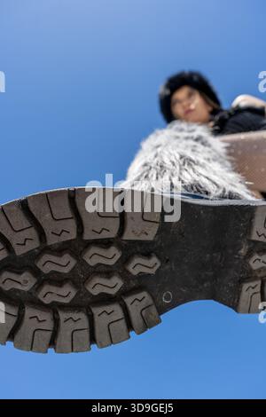 Woman wearing a fur hat and combat boot, stomping down with an ...