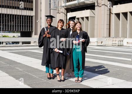 Diplomas in diversity. a diverse group of university students holding ...