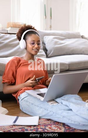 Young female student in warm autumn clothes coming out of the house ...