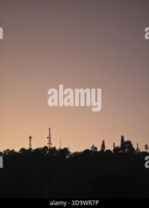 The silhouette of a hill against the glowing sunset sky during the ...