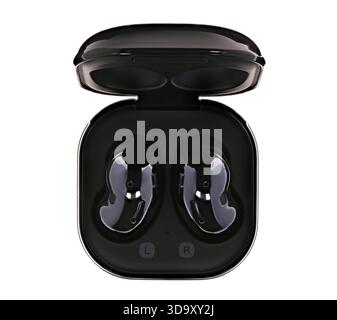 White earbuds in open case. Case rests on plain gray surface ...