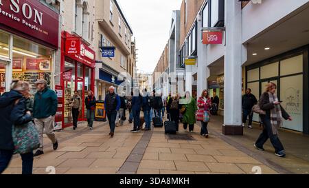 Shoppers navigating a busy pedestrian street amid modern retail ...