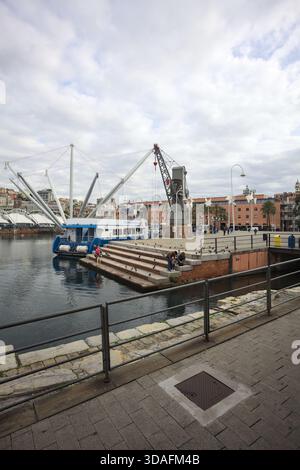 Genova, Italy - 14TH NOVEMBER 2025 - Boat moored next to an old crane ...