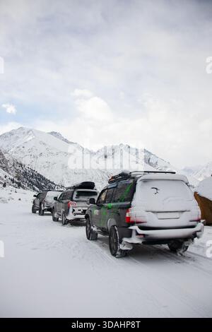 Rear view of several off-road vehicles parked on a dirt lot, including ...