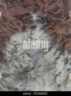 Aerial view of rugged, textured brown landscape with scattered green ...