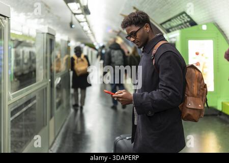 Black man standing at subway platform wearing coronavirus face mask ...