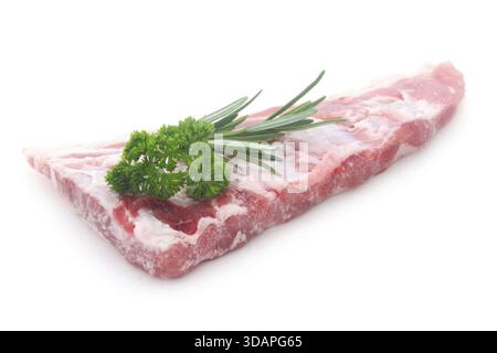 Raw pork ribs on light wood cutting board. Bright red cherry tomatoes ...
