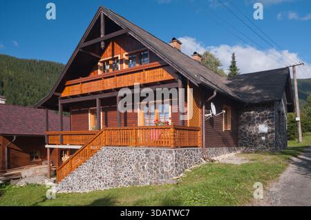 A cabin balcony view of greenery with blue sky and small white clouds ...