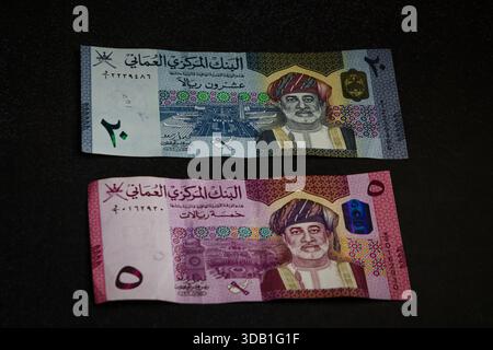 Omani rial banknotes denominations arranged on dark background, showing ...