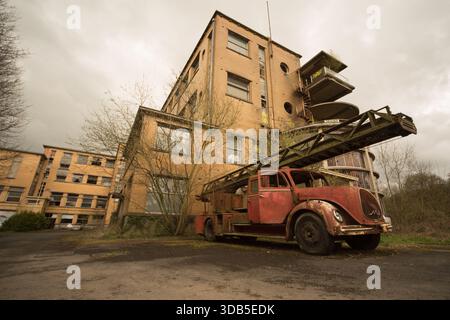 A fire truck with an extended ladder is parked on a street in front of ...