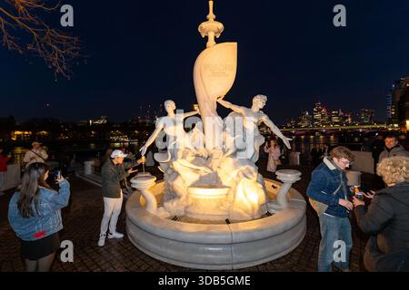 A crowd stands around the fountain. Visitors gathered around a ...