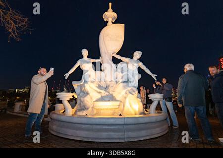 A crowd stands around the fountain. Visitors gathered around a ...